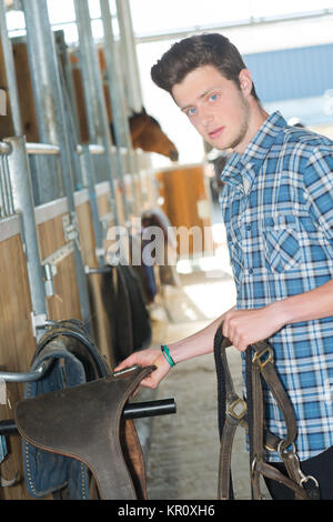 handsome young stable boy posing Stock Photo - Alamy