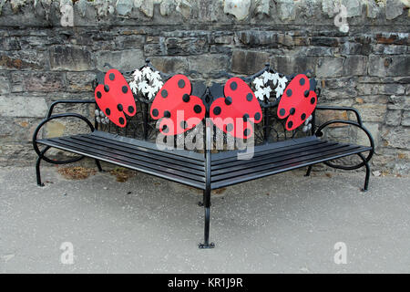 A metal bench with red ladybugs Stock Photo - Alamy
