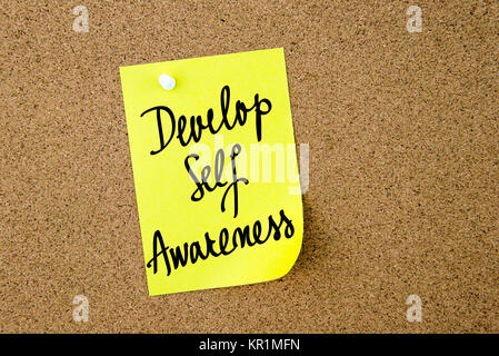 Develop Self Awareness written on yellow paper note pinned on cork ...