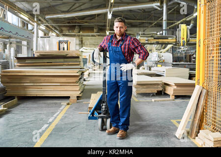 Young Warehouse Mover Pulling Cart Stock Photo - Alamy