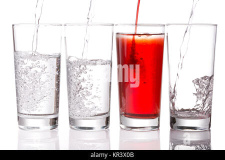 Pouring Squash into Glass of Water close up with a white background ...
