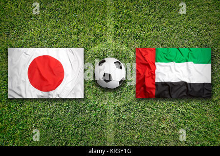 Japan vs. United Arab Emirates flags on green soccer field Stock Photo ...