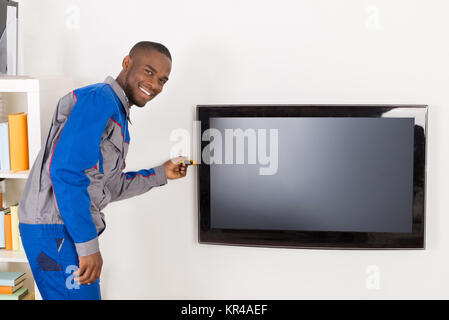 Tv repairman technician repairing tv at home Stock Photo - Alamy