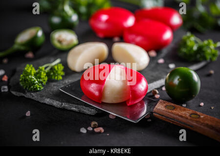 Stack of mini cheese in red wax on wooden table Stock Photo - Alamy