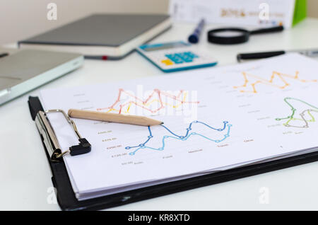 office desk with stationary. Business Graph on screen Stock Photo - Alamy
