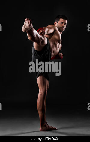 A young man does body attack jump while teaching a body attack class ...