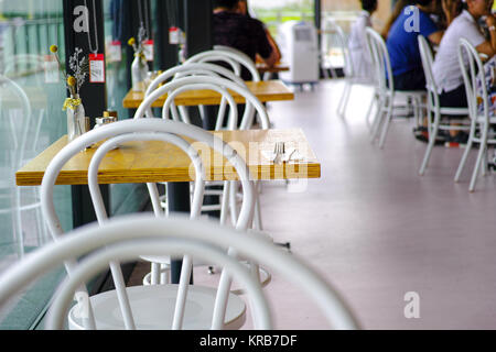 Bright modern cafe interior with big windows, wooden tables and white ...
