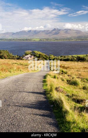 A narrow mountain pass road leads down the slopes of Caherconree ...