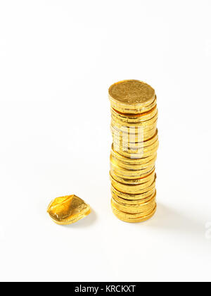 A stack of gold chocolate coins wrapped in a golden foil Stock Photo ...