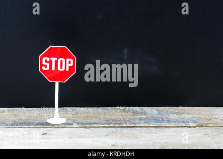 Mini STOP sign over chalkboard background and table, STOP EXCUSES ...