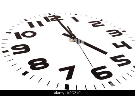 Five o'clock on the alarm. A white alarm clock is on a white table. The ...