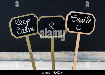 Keep Calm and Smile message written with chalk on mini blackboard ...