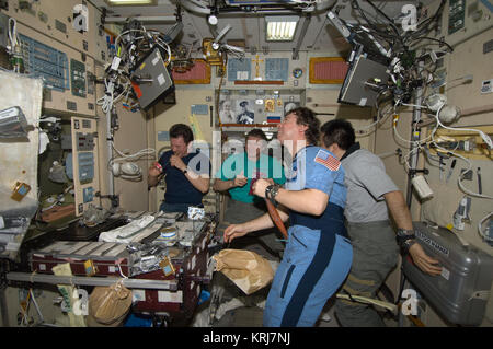 ISS-20 Crew members share a meal at a galley in the Unity node of the ...