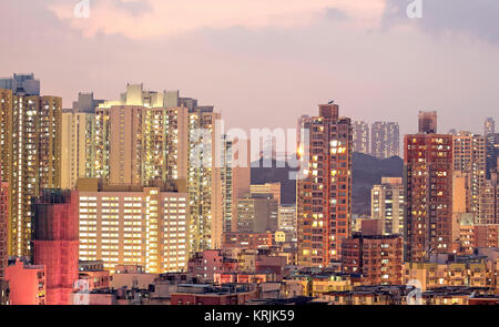 A nighttime cityscape with lit buildings and a busy road illuminated by ...