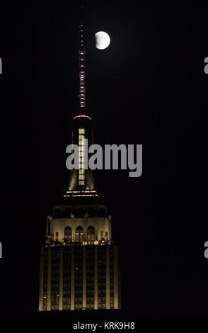 A full moon is seen next to the Empire State Building on Manhattan ...