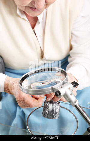 threading the needle under the magnifying glass grandma's hobby ...