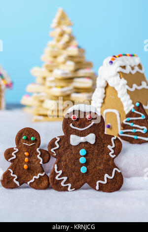 decorated gingerbread houses with white icing, candy, and popcorn ...