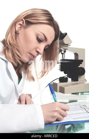 Young woman scientist writing report listening audio message at ...