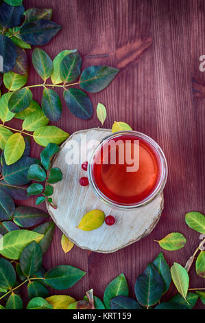 Glass cup of hot rowan tea and berries on color background Stock Photo ...