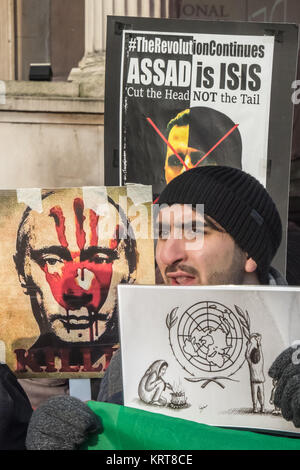 Putin, Assad and a ISIS balaclava on posters behind a protester at the ...