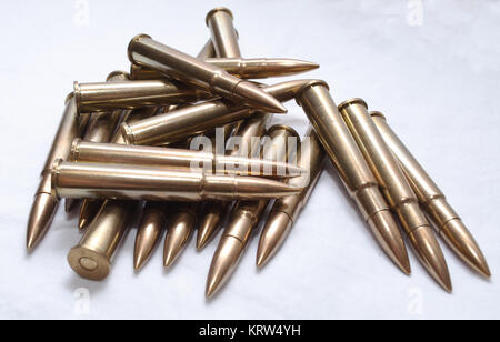 Several large caliber rifle bullets together on a white background ...
