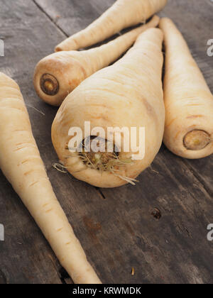 Five raw parsnip on a wooden kitchen table, view from above Stock Photo ...