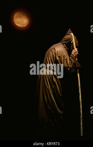 Monk with stick at night Stock Photo - Alamy