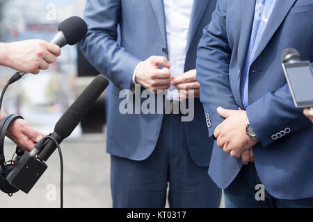 Journalists holding microphones, conducting press interview Stock Photo - Alamy