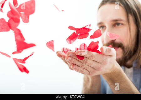Man blowing paper hearts Stock Photo - Alamy
