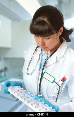 Histologist with a microscope and a tray of microscopic slides on a ...