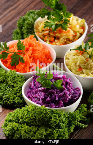 Composition with four vegetable salad bowls on wooden table Stock Photo ...