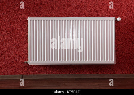white heating radiator under in red room Stock Photo - Alamy