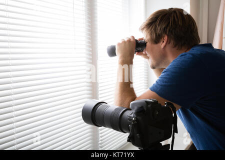 Private Detective Spying With Binoculars Looking Through Blinds Near ...