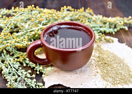 Tea with wormwood in brown cup on dark board Stock Photo - Alamy