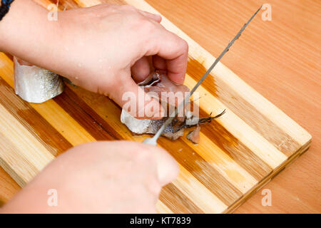 Female hands with knife slicing fish hake Stock Photo - Alamy