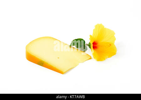 slice of gouda cheese with hibiscus flower on wooden cutting board ...
