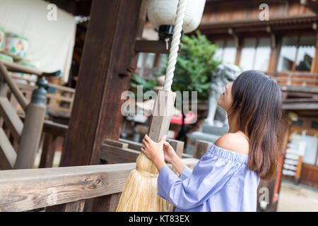 Woman ringing bell at Shinto shrine of Sumiyoshi Taisha, Osaka, Kansai ...