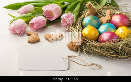 Easter yellow painted eggs and biscuits bunny in a basket on bright ...