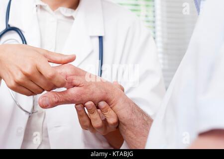 Nurse checking man's hand joints, close up Stock Photo - Alamy