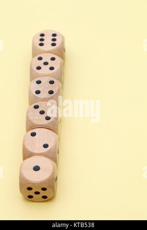 Row of many wooden dice on a yellow background Stock Photo - Alamy