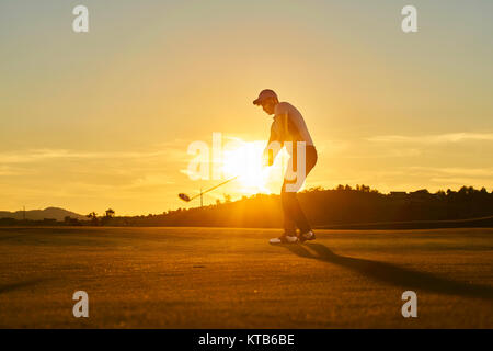 Man playing golf ion the evening Stock Photo - Alamy