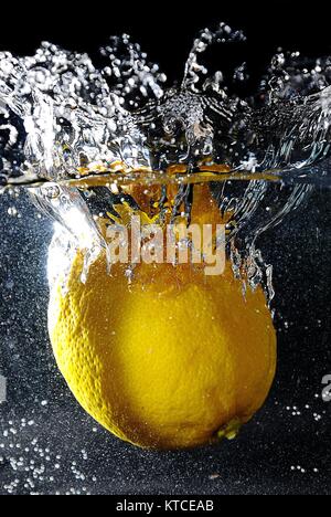 Close up view of falling lemon into water. Healthy food concept Stock ...