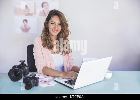 Pretty photographer working at laptop Stock Photo - Alamy