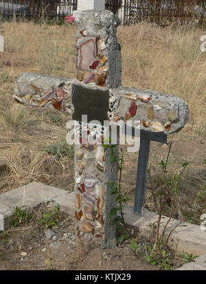 Catholic grave in a cemetery marked with a wooden cross with rosary ...