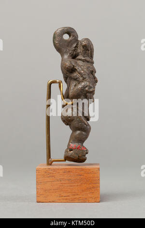 The image depicts a figure of Bes, an ancient Egyptian deity, shown ...