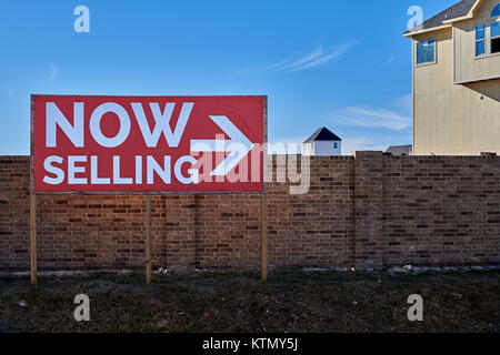Now Selling Sign Posted in Front of a New Construction Home in a Up-and ...