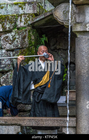 Local Monk drinking water from Otowa Waterfall (Otowa-no-Taki) which is ...