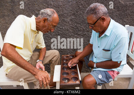 Local men playing mancara, also known as ouril, oware, uril, ouri, ori ...