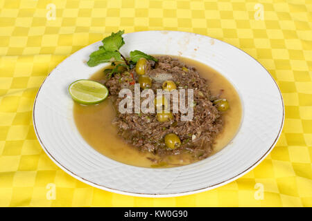 Veal ripped meat served in a white dish marinated with olives, and a ...