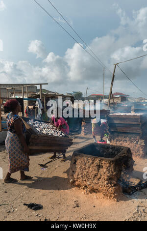 Two women smoking fish over a clay oven, Jamestown Fishing Village ...